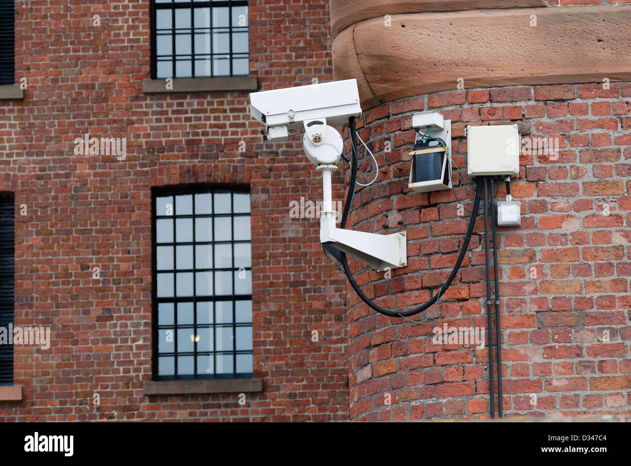 Security camera mounted on a building wall Stock Photo - Alamy