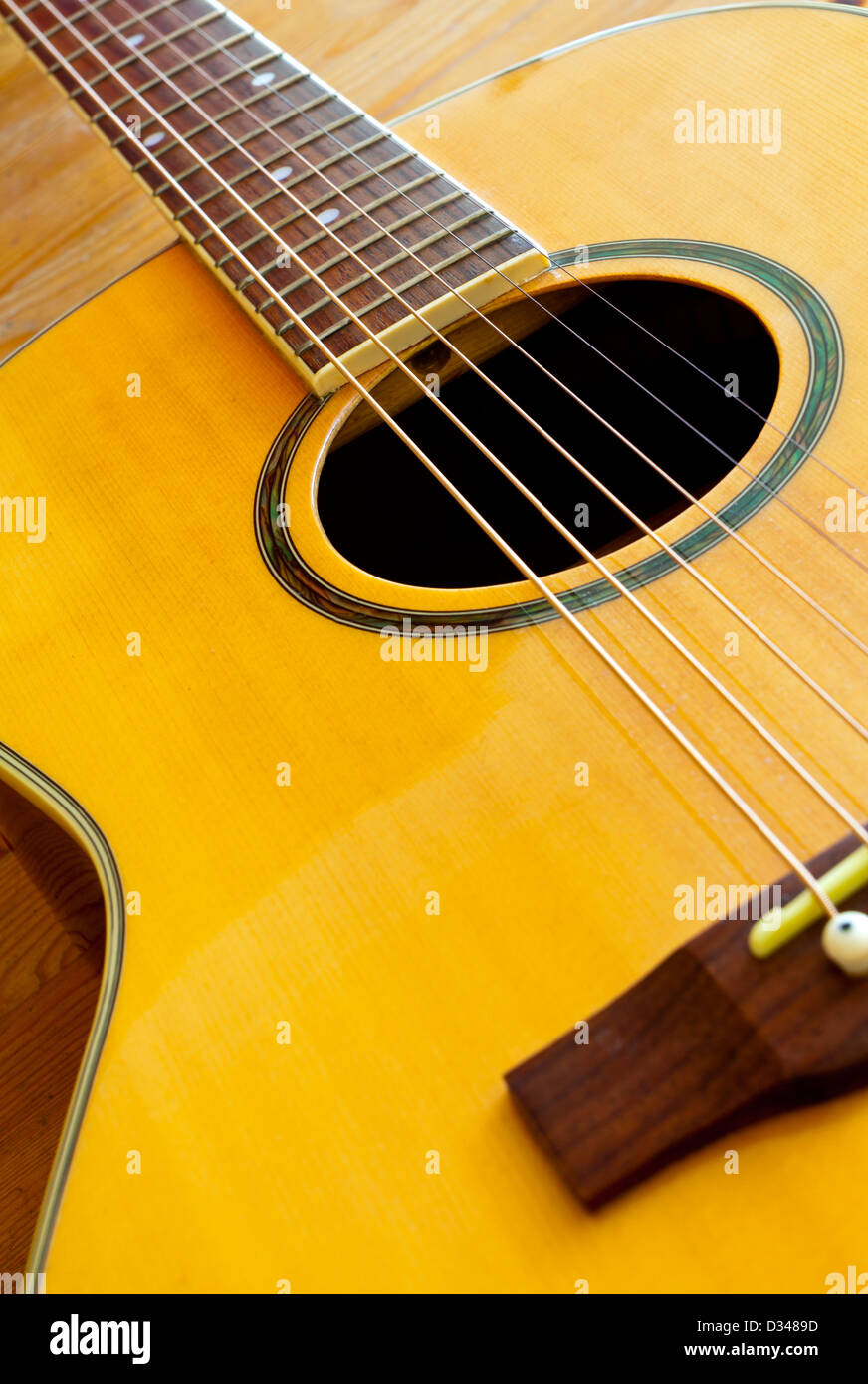 Detail of six stringed acoustic guitar showing part of the neck with ...