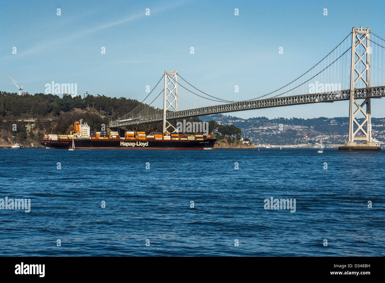 Container cargo ship passing under the Bay Bridge in San Francisco ...