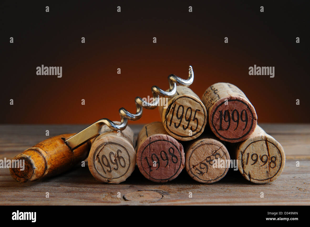 Closeup of a group of wine corks and a corkscrew on a rustic wood table ...