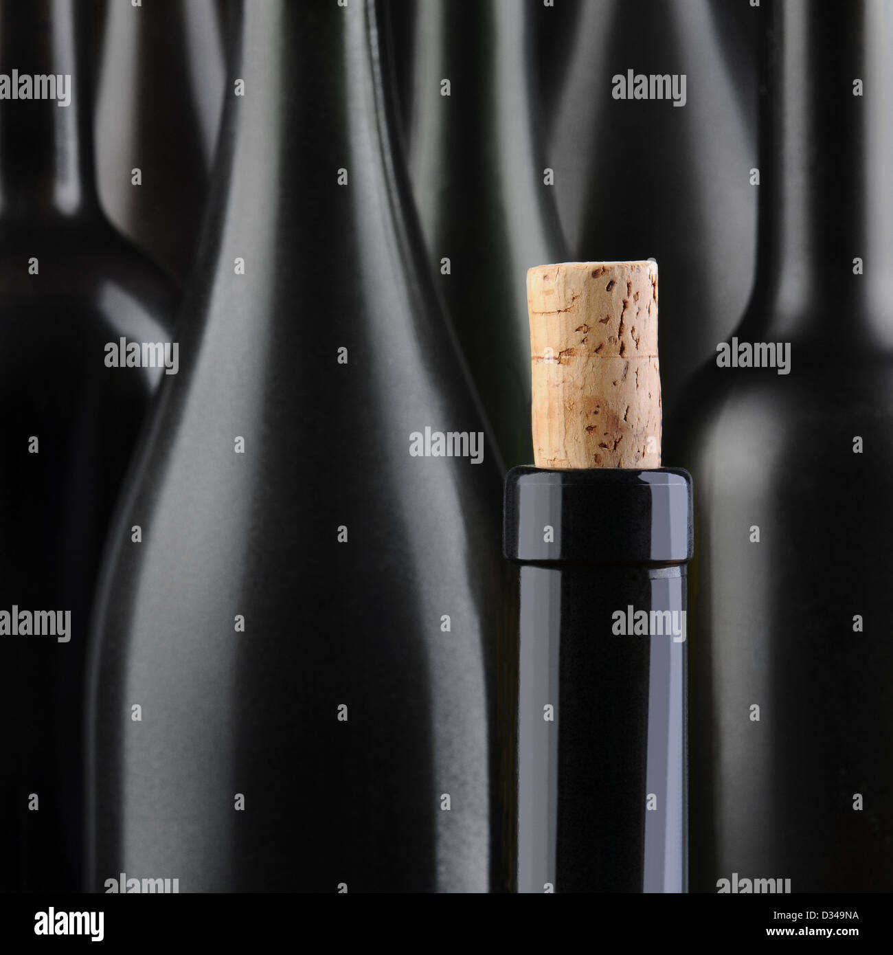 Closeup of a wine bottle with the cork partially out, in front of an ...