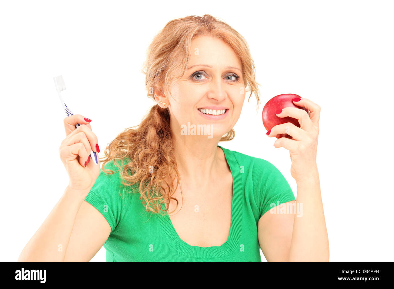 Smiling woman holding a red apple and tooth brush isolated on white ...