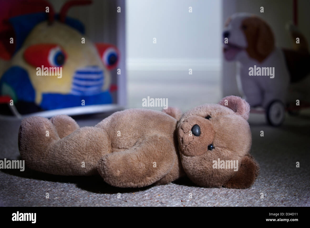 Brown teddy bear laying on a child's bedroom floor Stock Photo - Alamy