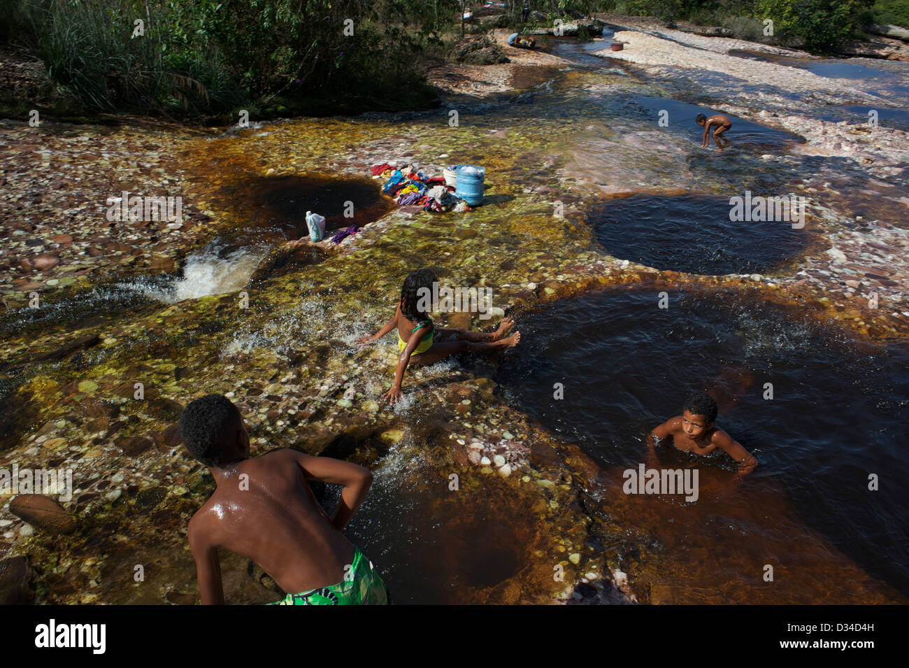 washing cloths on one side,on the other,children sliding on the water ...