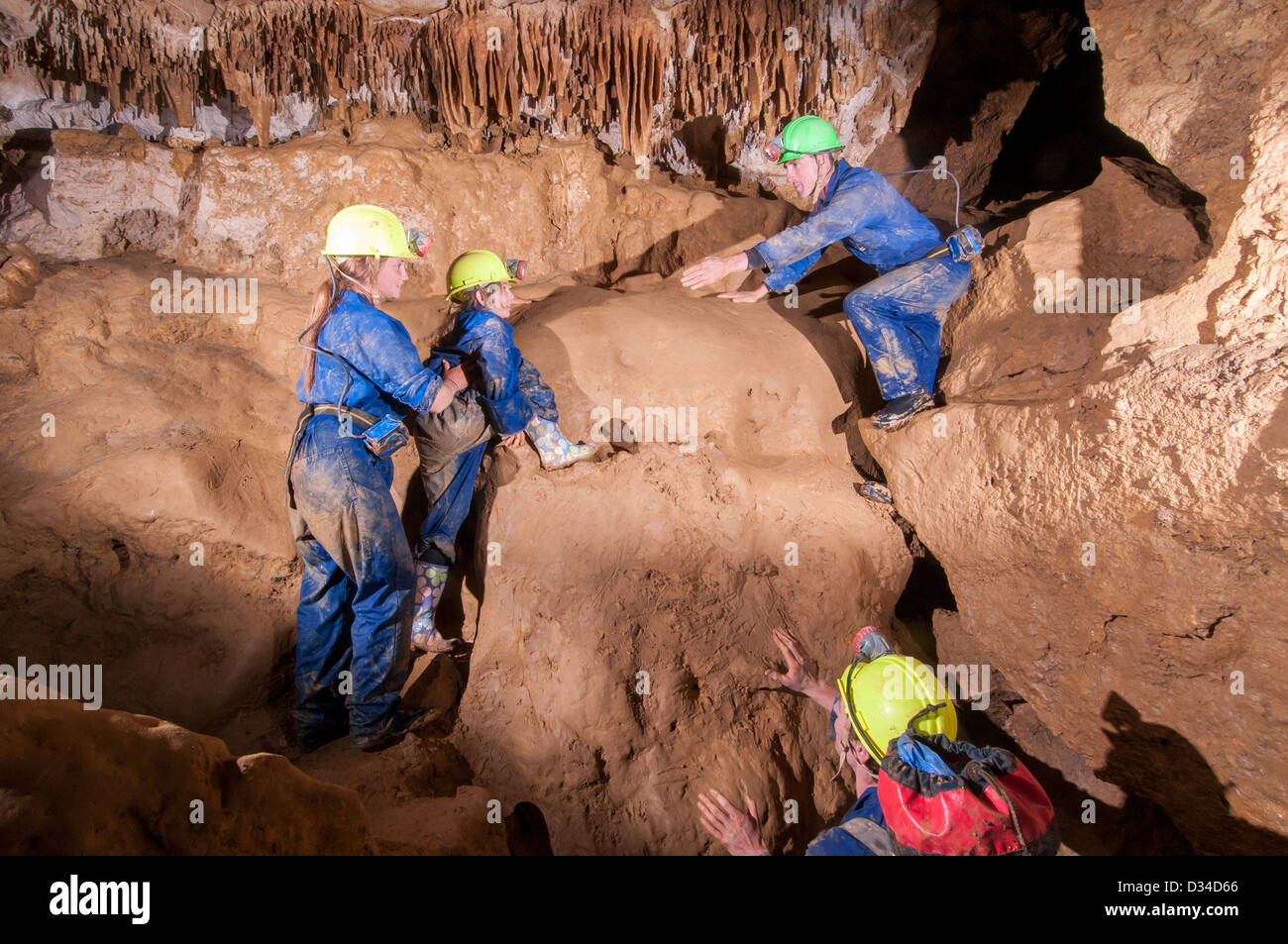 People caving in the waikato, with guides helping young girl across ...