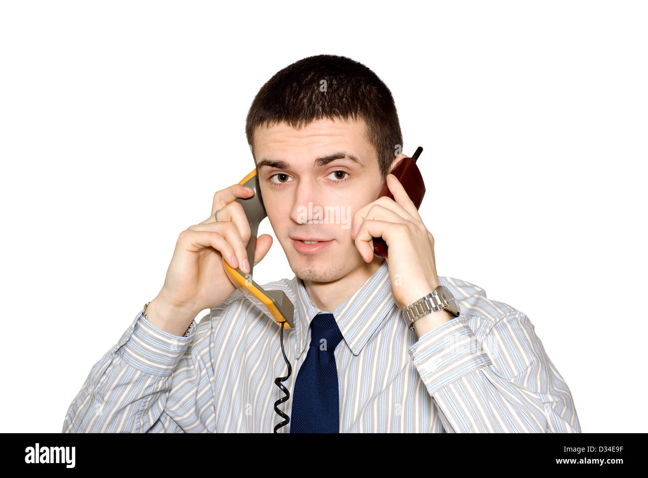 The young man speaks simultaneously by two phones Stock Photo - Alamy