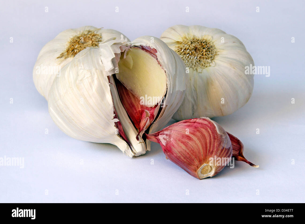 Three garlics in a grey background Stock Photo - Alamy