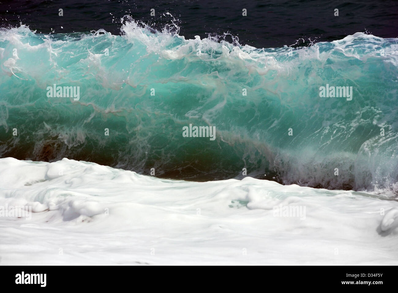 Blue coastal waves and sand Stock Photo - Alamy