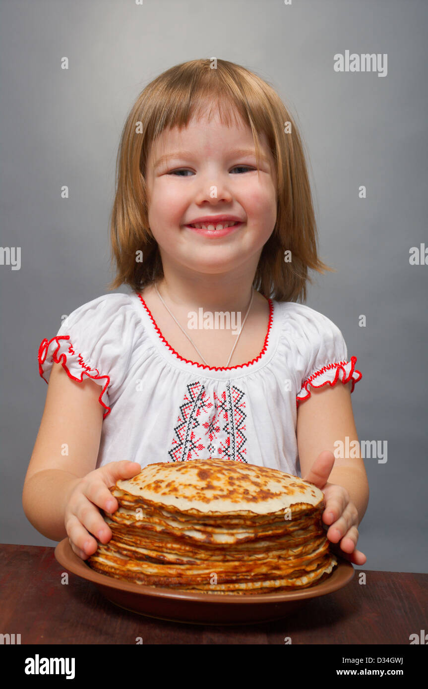 Russian little girl eats pancakes with red caviar Stock Photo - Alamy