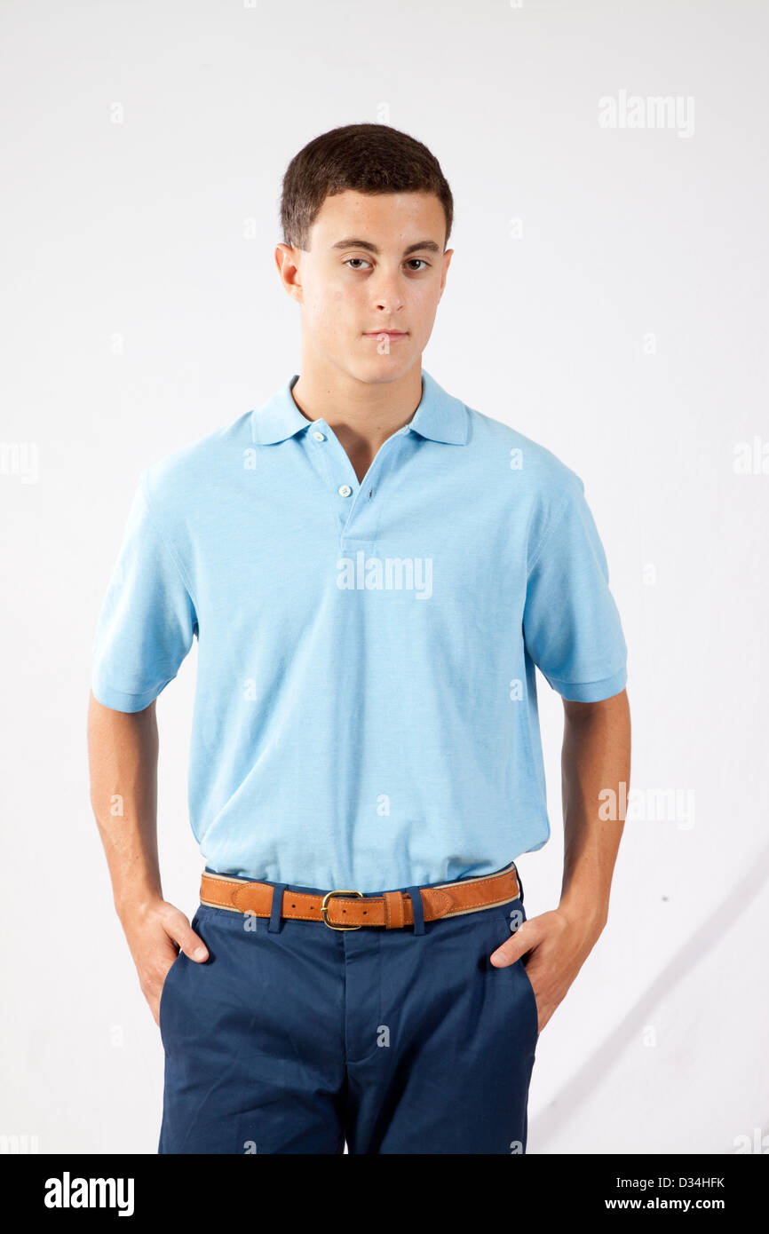 Handsome white teenager in a blue shirt and dark blue slacks with a ...