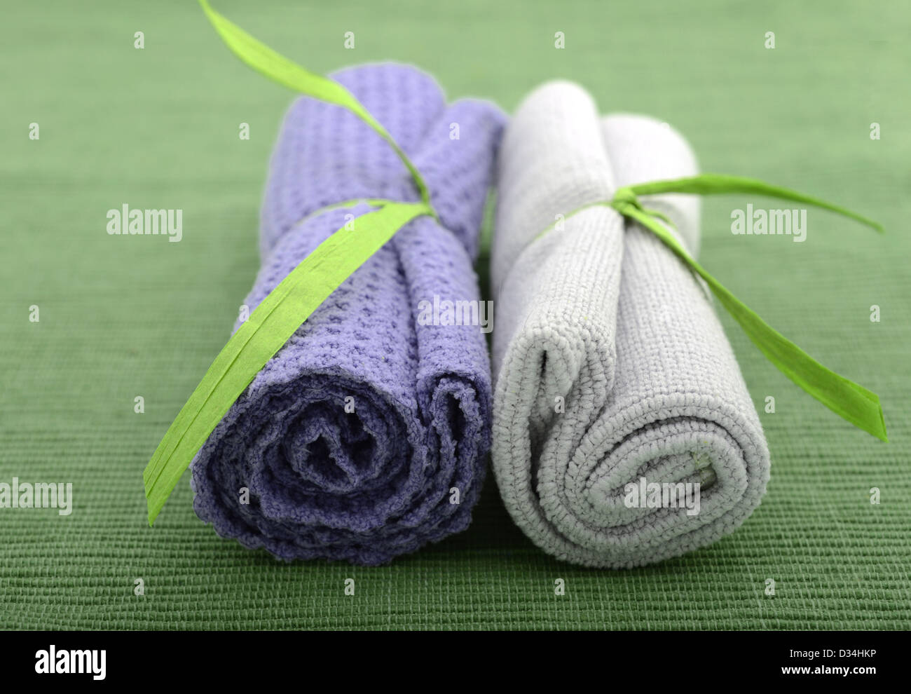 Purple and green wash cloths rolled up for bath at spa Stock Photo - Alamy