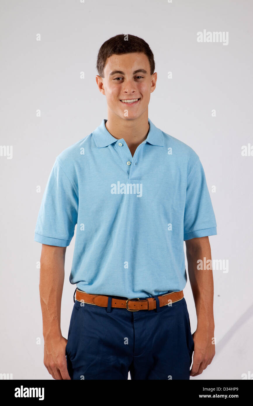 Teenage boy standing wearing blue golf shirt and dark blue slacks ...