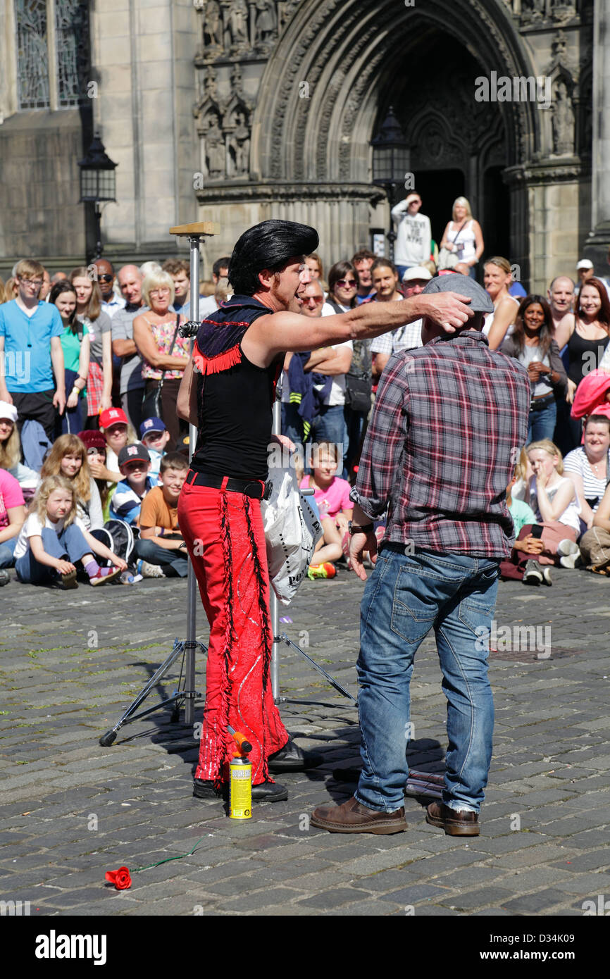 Street performer interacting with a volunteer from the audience at the ...