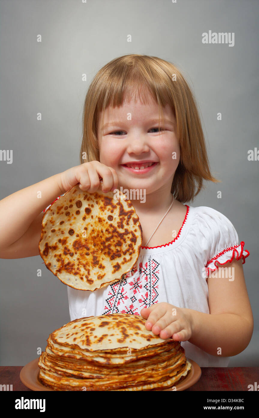 Russian little girl eats pancakes with red caviar Stock Photo - Alamy