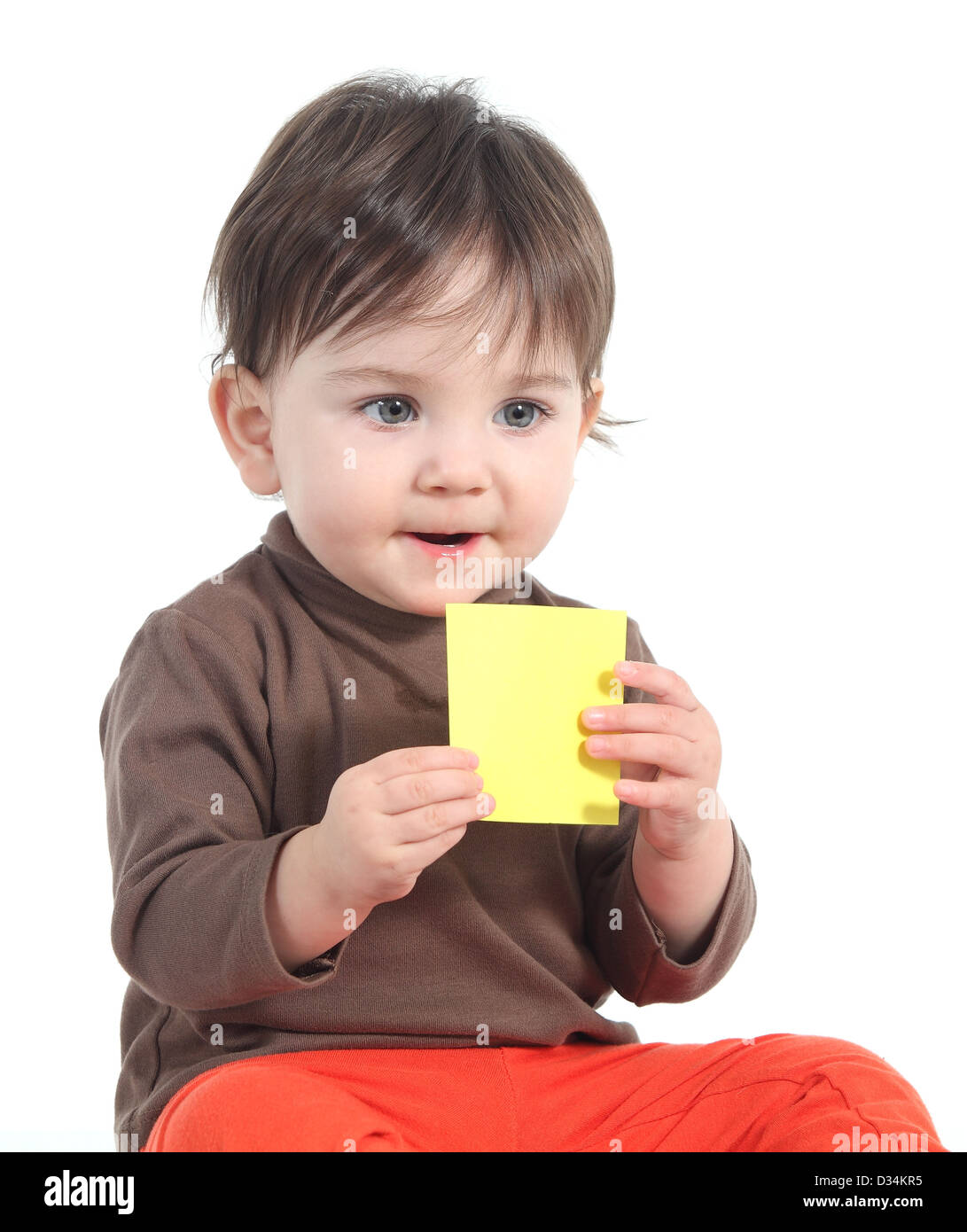 Baby holding and showing a blank yellow note on a white isolated ...