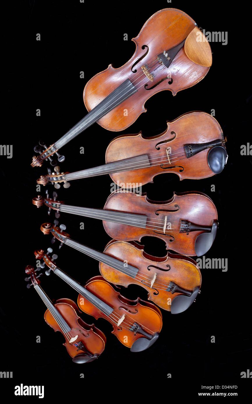different sized fiddles on black background Stock Photo - Alamy