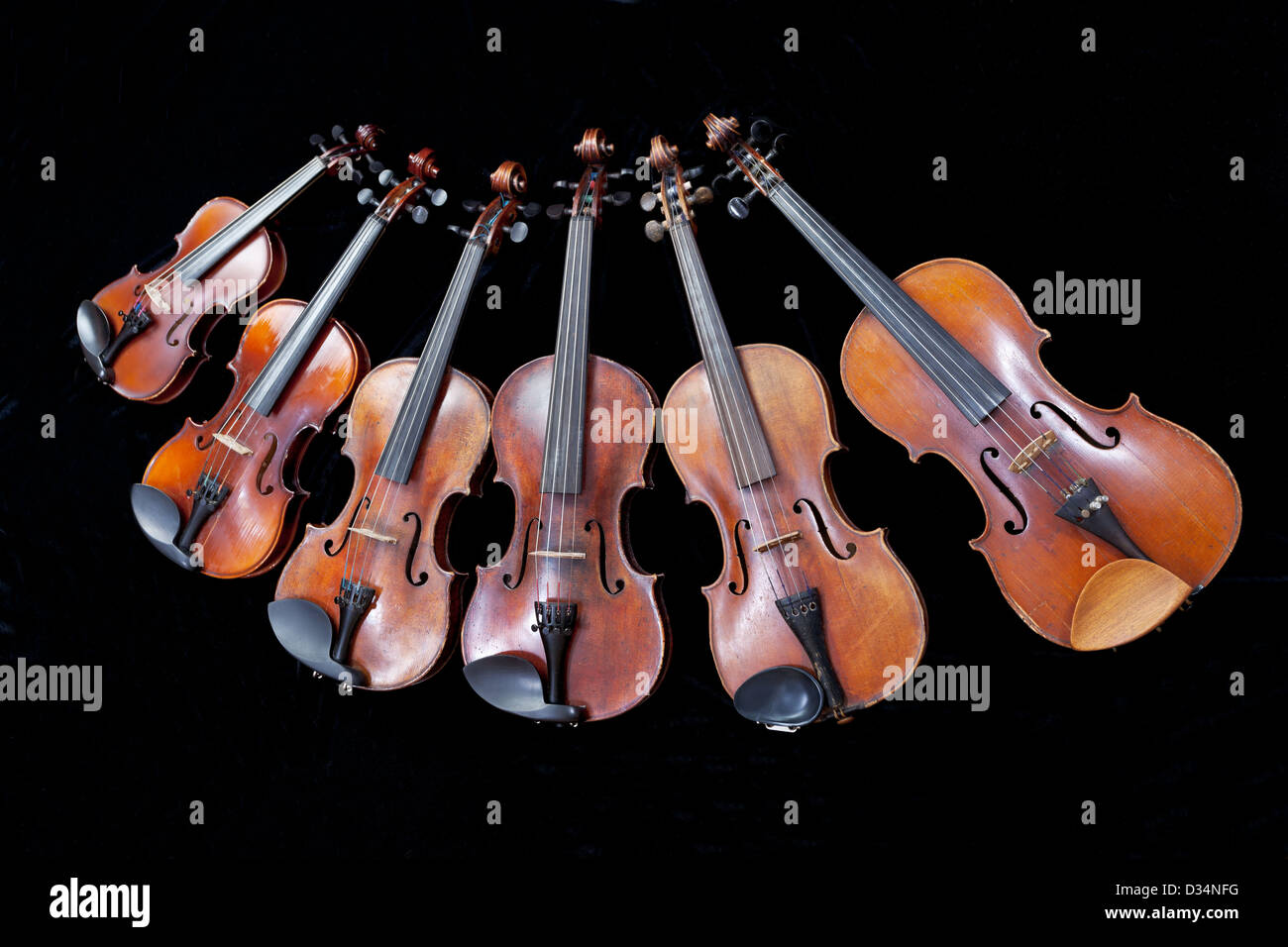 family of different sized violins on black background Stock Photo - Alamy