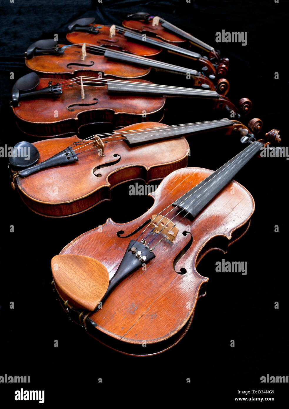 different sized fiddles with black background close up Stock Photo - Alamy