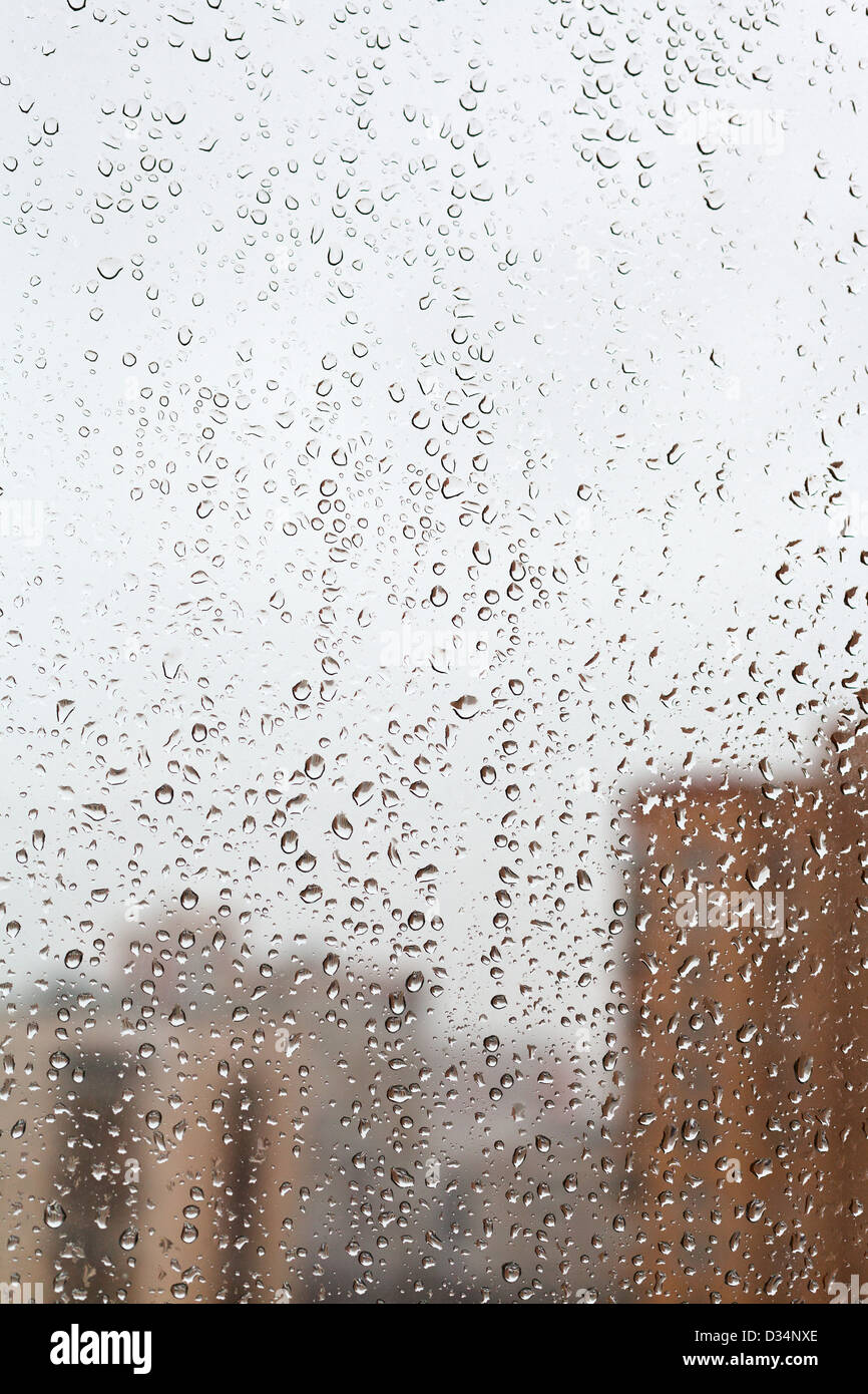 raindrops on glass window with town house background Stock Photo - Alamy