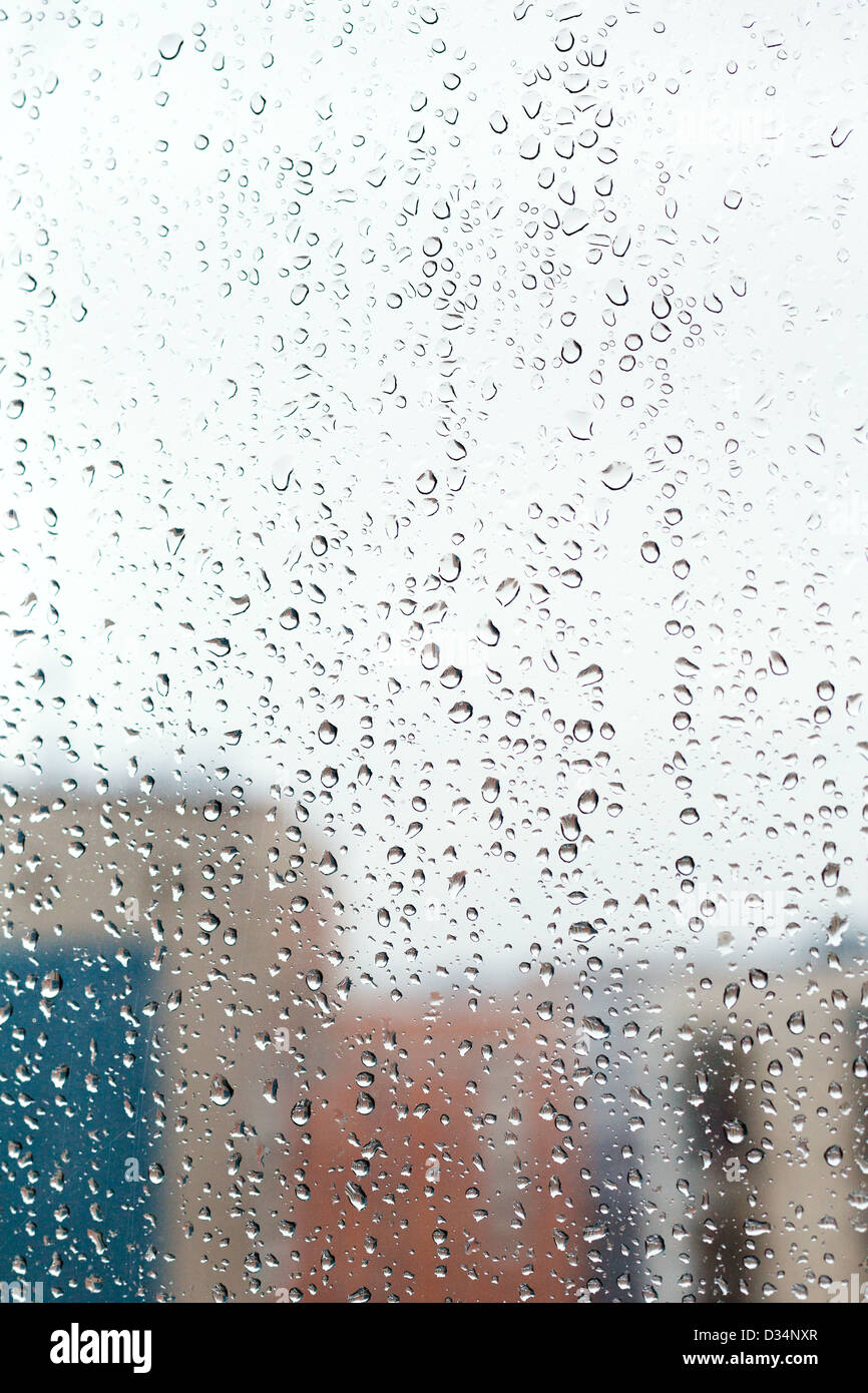 rain drops on glass window with houses background Stock Photo - Alamy