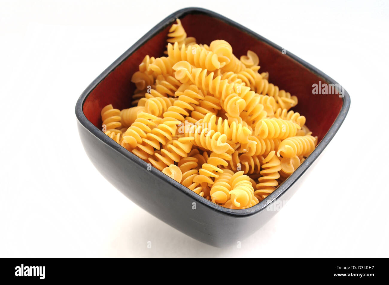 Rotelli pasta in red bowl on white background Stock Photo - Alamy