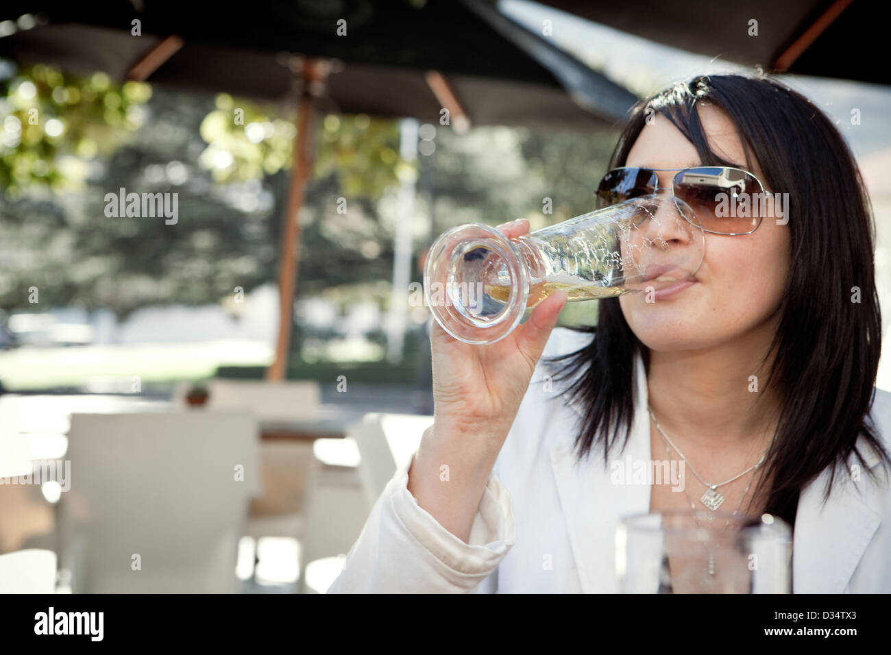 A lady drinking a beer in a garden of a French Restaurant in ...