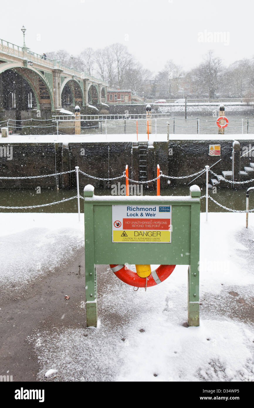 Richmond Lock and weir - snow covered pedestrian bridge, danger sign ...