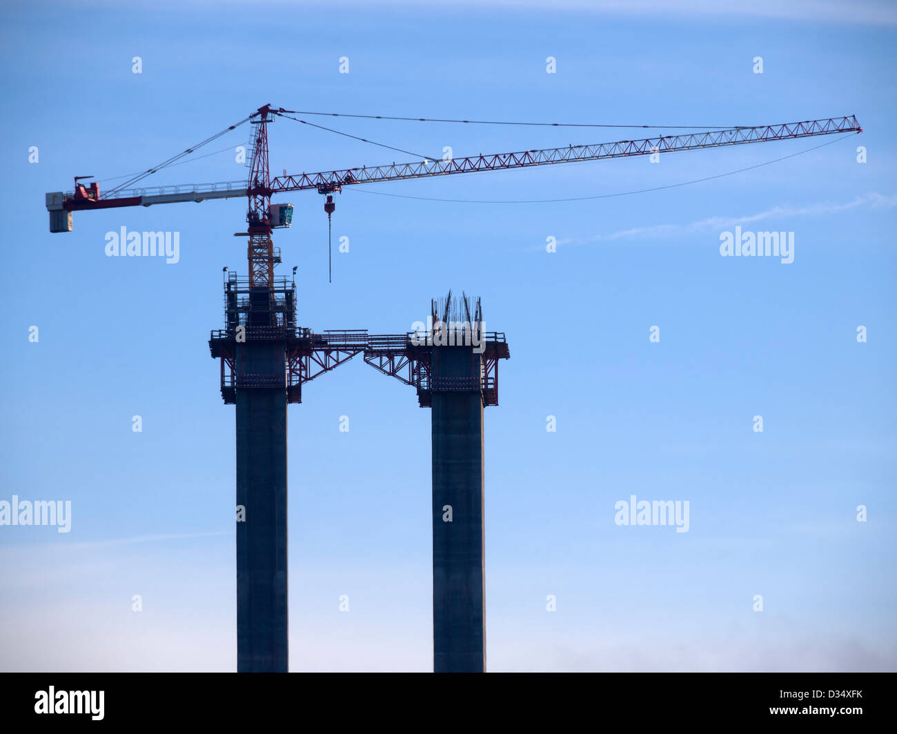 Construction crane building bridge pillars against a blue sky Stock ...