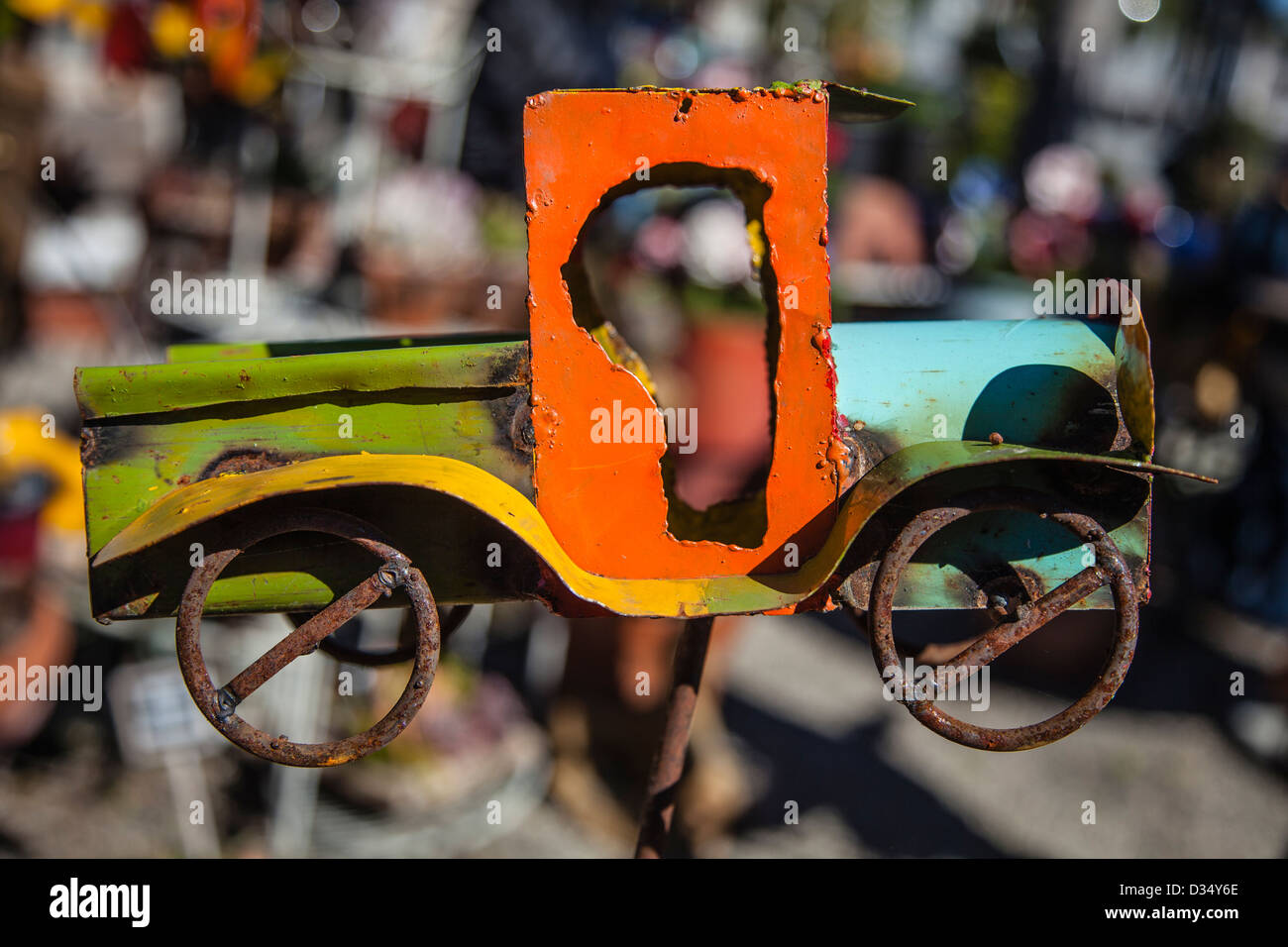 A multicolored primitive toy truck on a rusted metal rod created for ...