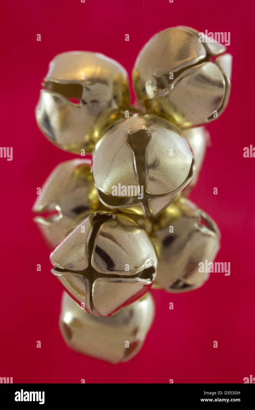 Golden miniature bells against red background Stock Photo - Alamy