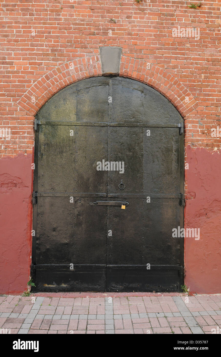 red brick building with black doors with padlock to keep out Stock ...