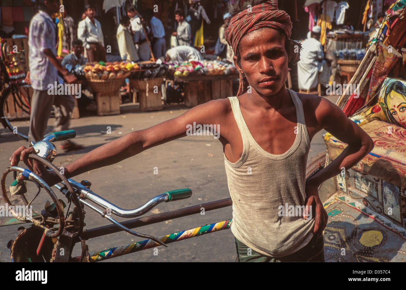 Portrait of a cycle rickshaw rider standing next to his rickshaw, Dhaka ...