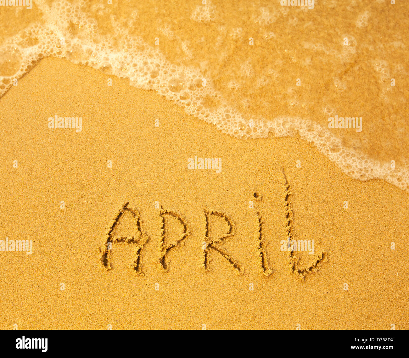 April - written in sand on beach texture - soft wave of the sea (months ...