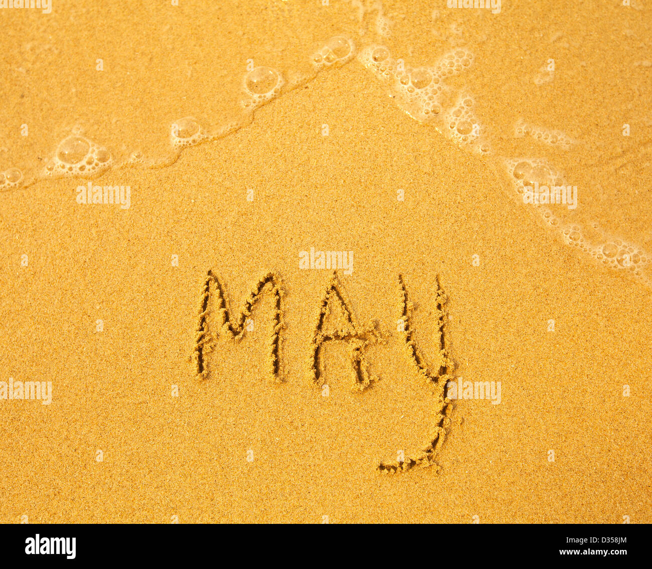 May - written in sand on beach texture - soft wave of the sea (months ...