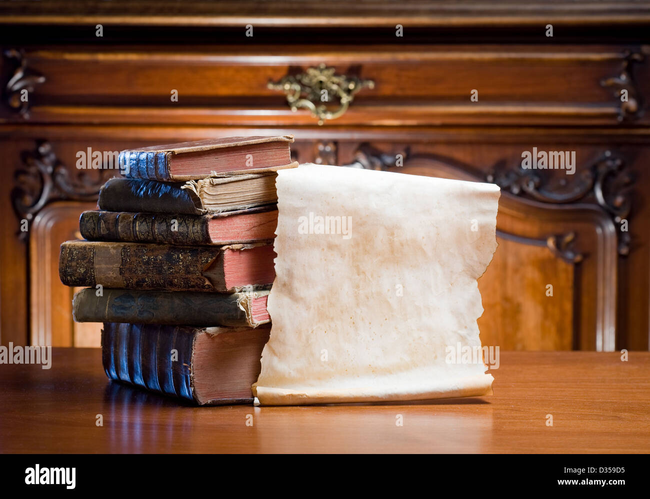 Old worn paper scroll with copy space next to antique books Stock Photo ...