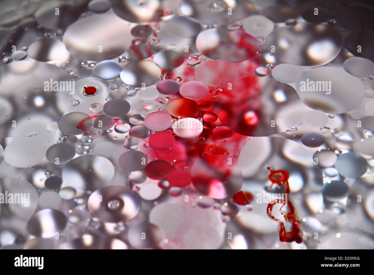 Red dye mixed with oil and water Stock Photo - Alamy