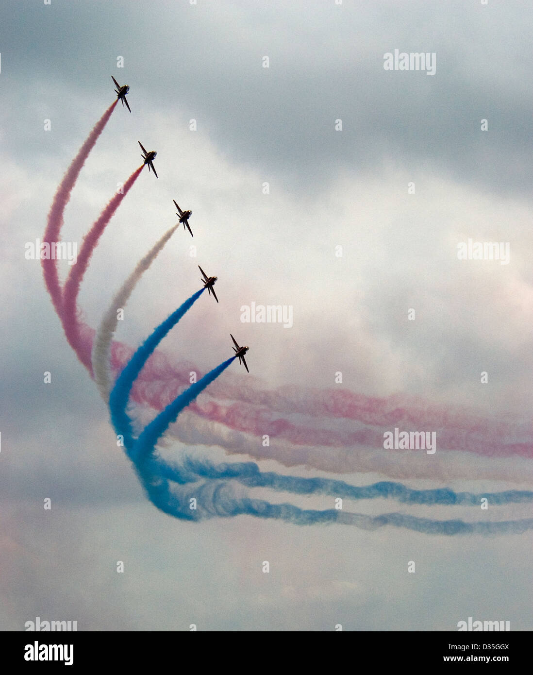 Red Arrows flying in formation to form a curve, with red, white and ...