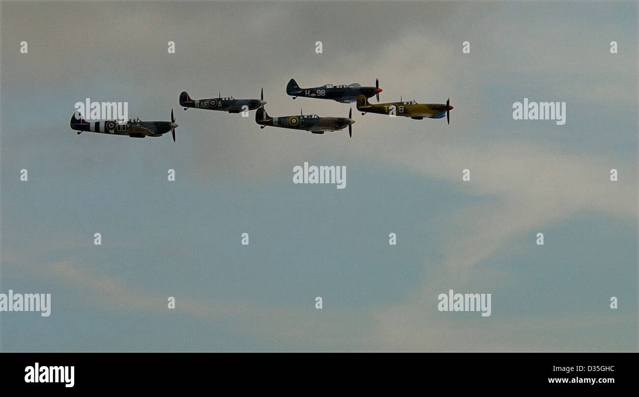 Five Spitfires flying in formation, in profile, against hazy overcast ...