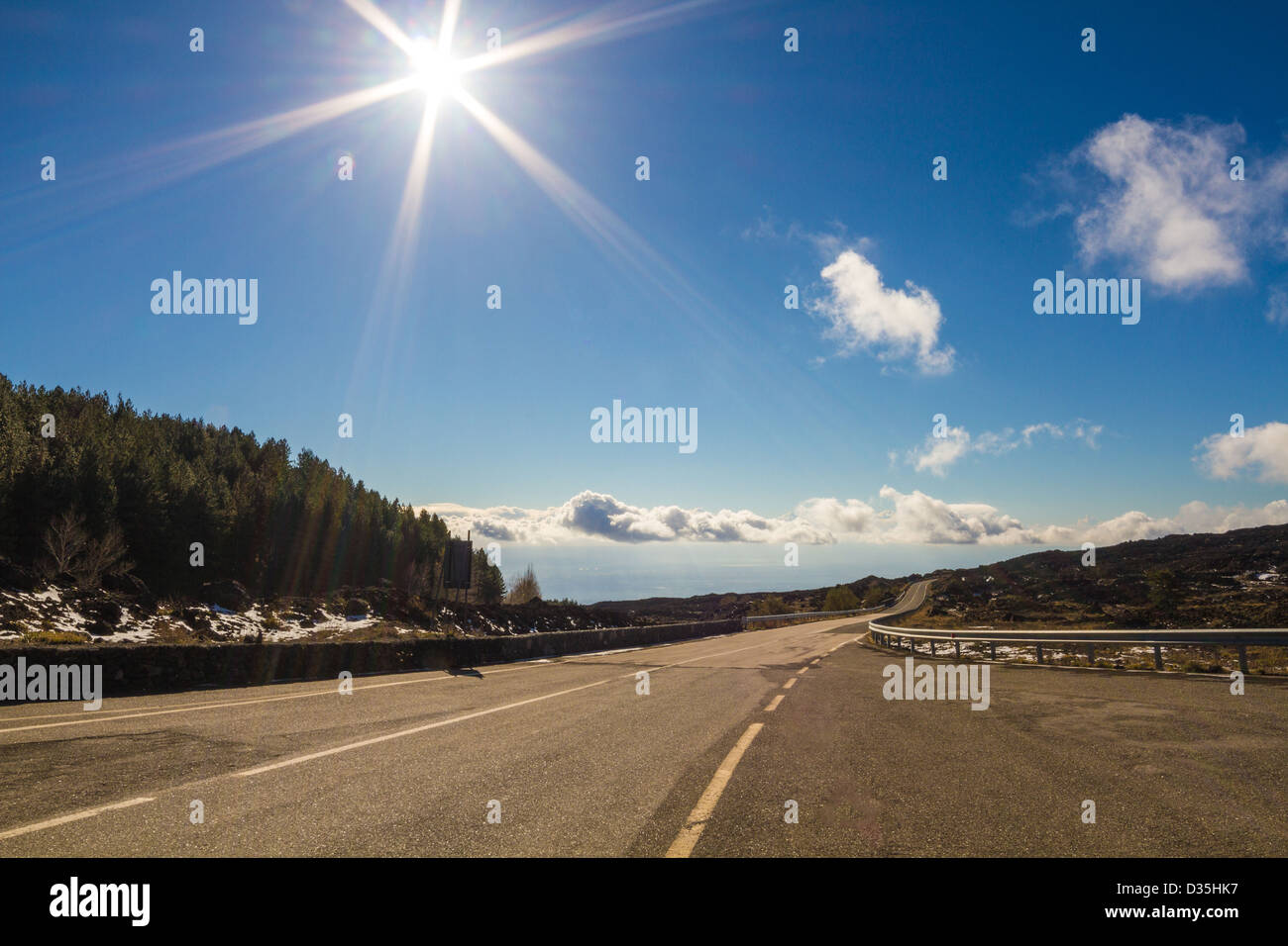 Long, lonely road in front of blue sky and mountains Stock Photo - Alamy