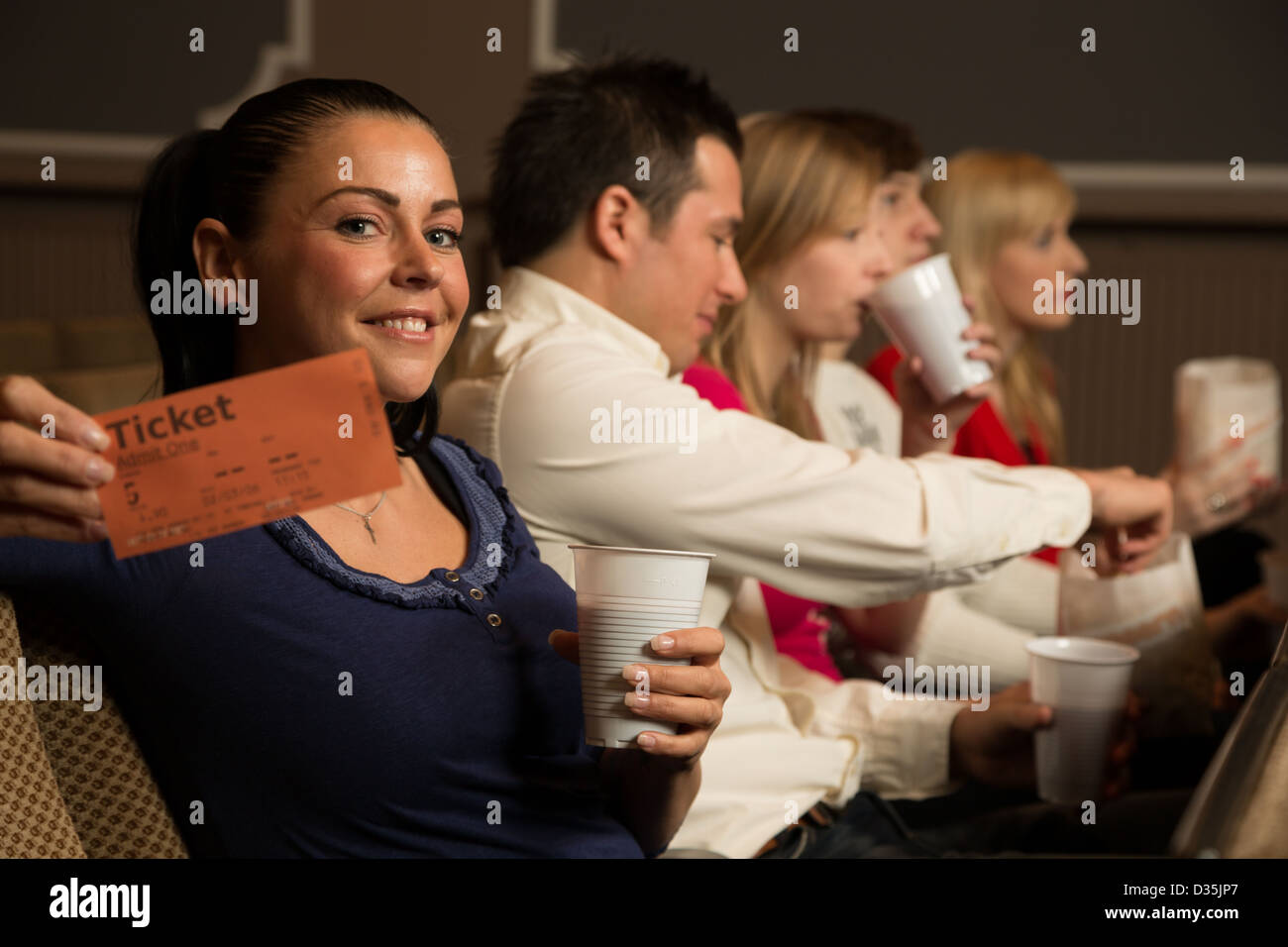 A woman in the audience of a theatre, in a concert hall or a cinema ...