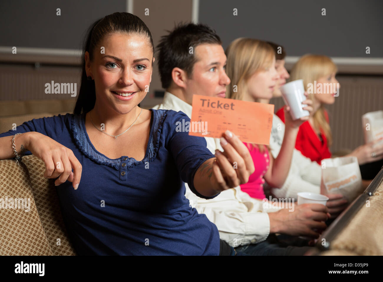 A woman in the audience of a theatre, in a concert hall or a cinema ...