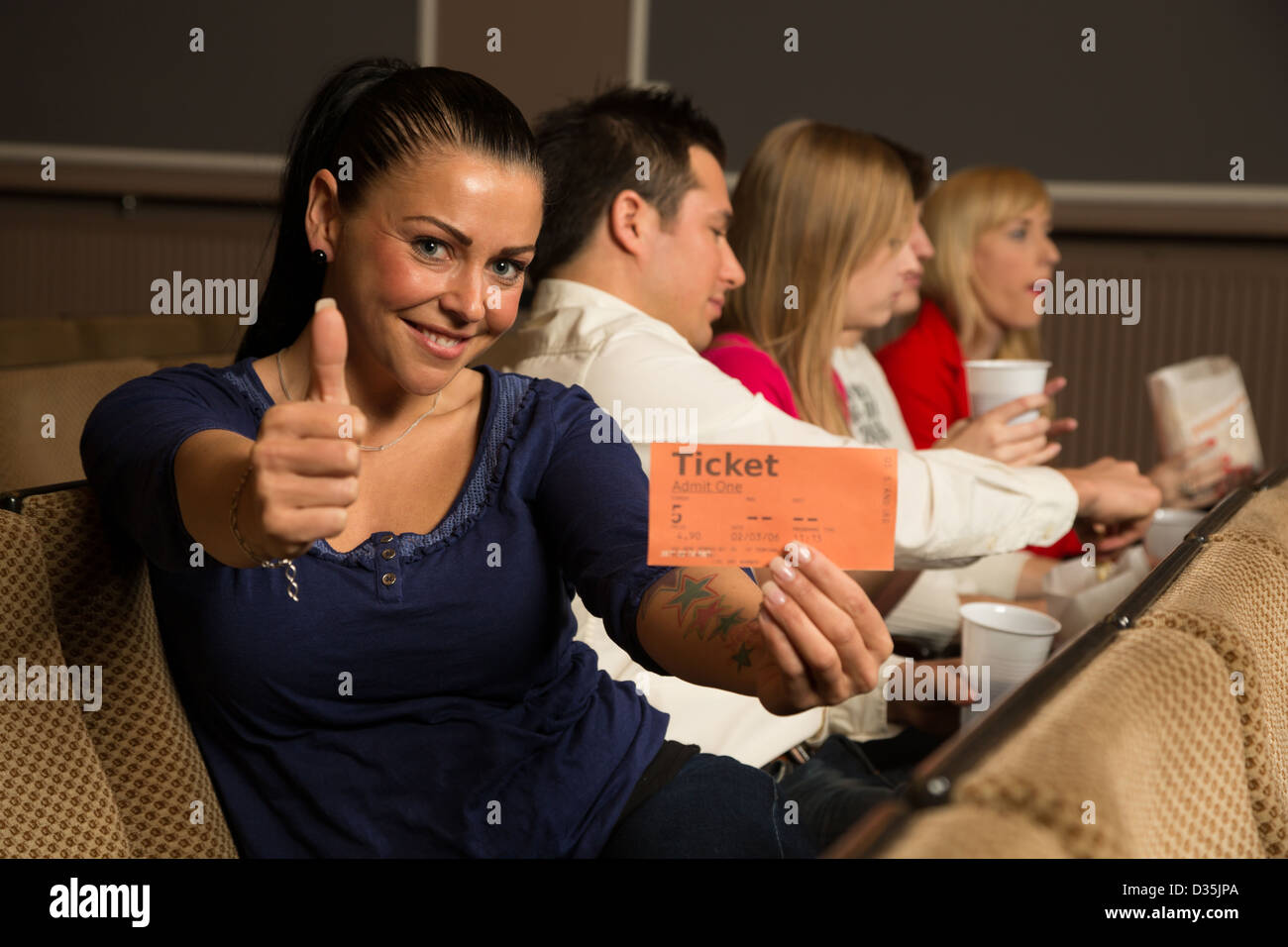 A woman in the audience of a theatre, in a concert hall or a cinema ...