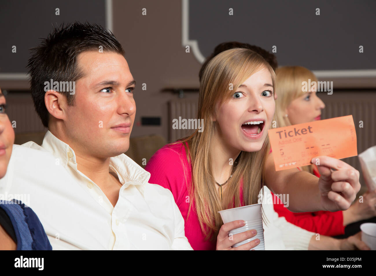 A woman in the audience of a theatre, in a concert hall or a cinema ...