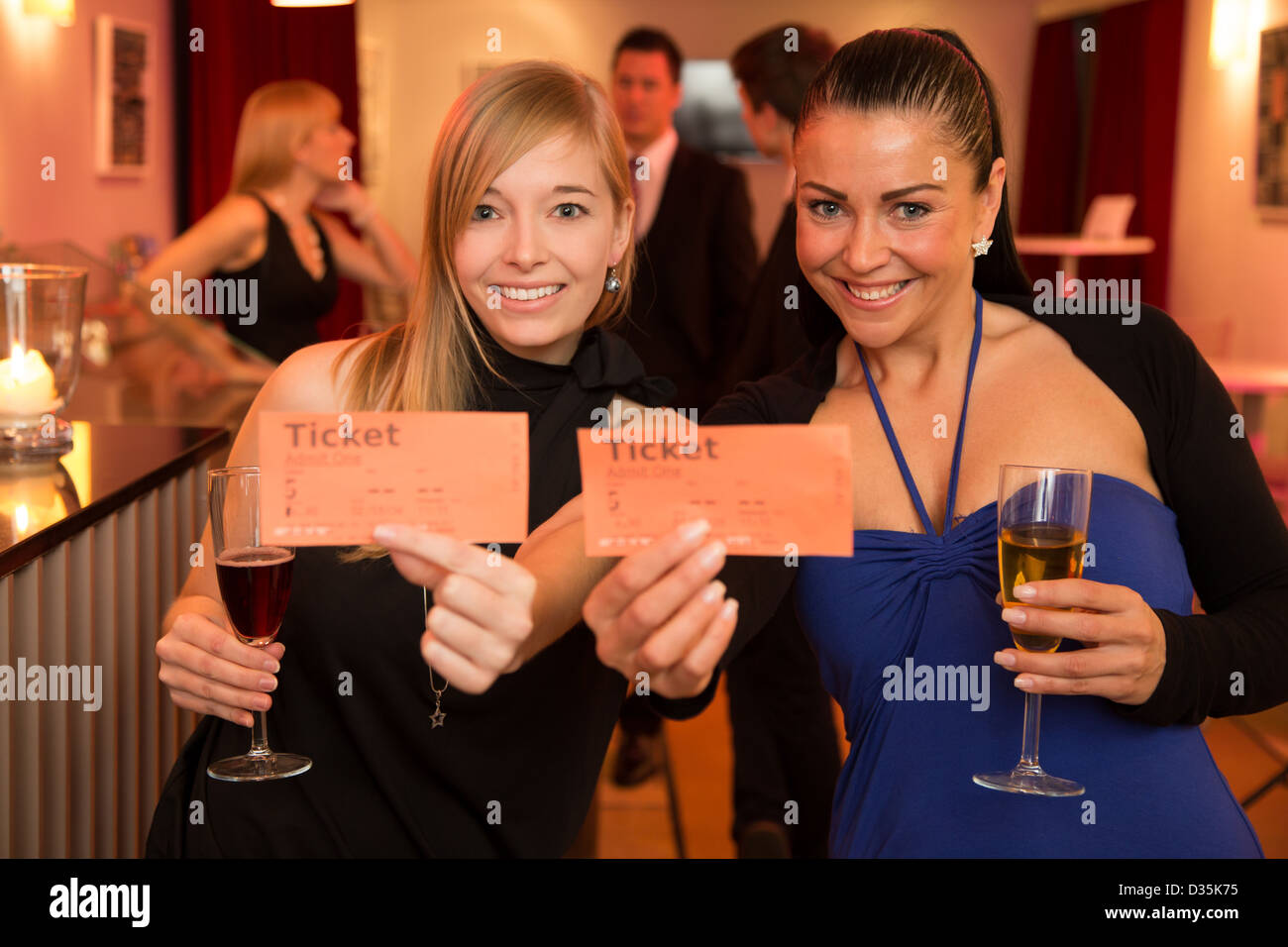 Two beautiful women presenting tickets for a theatre, cinema or a ...