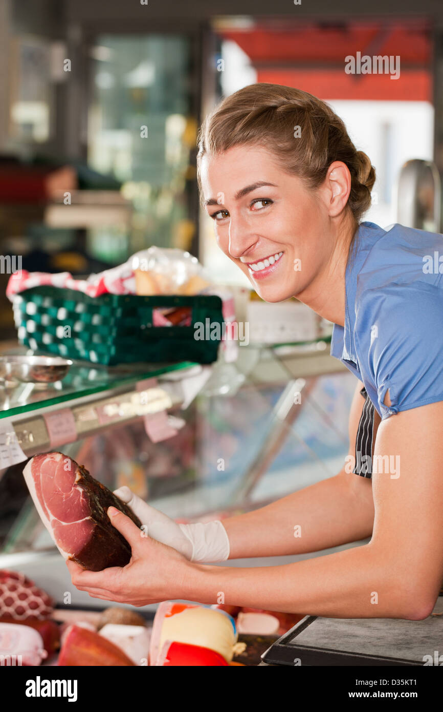 Portrait of beautiful butcher smiling while holding raw meat Stock ...