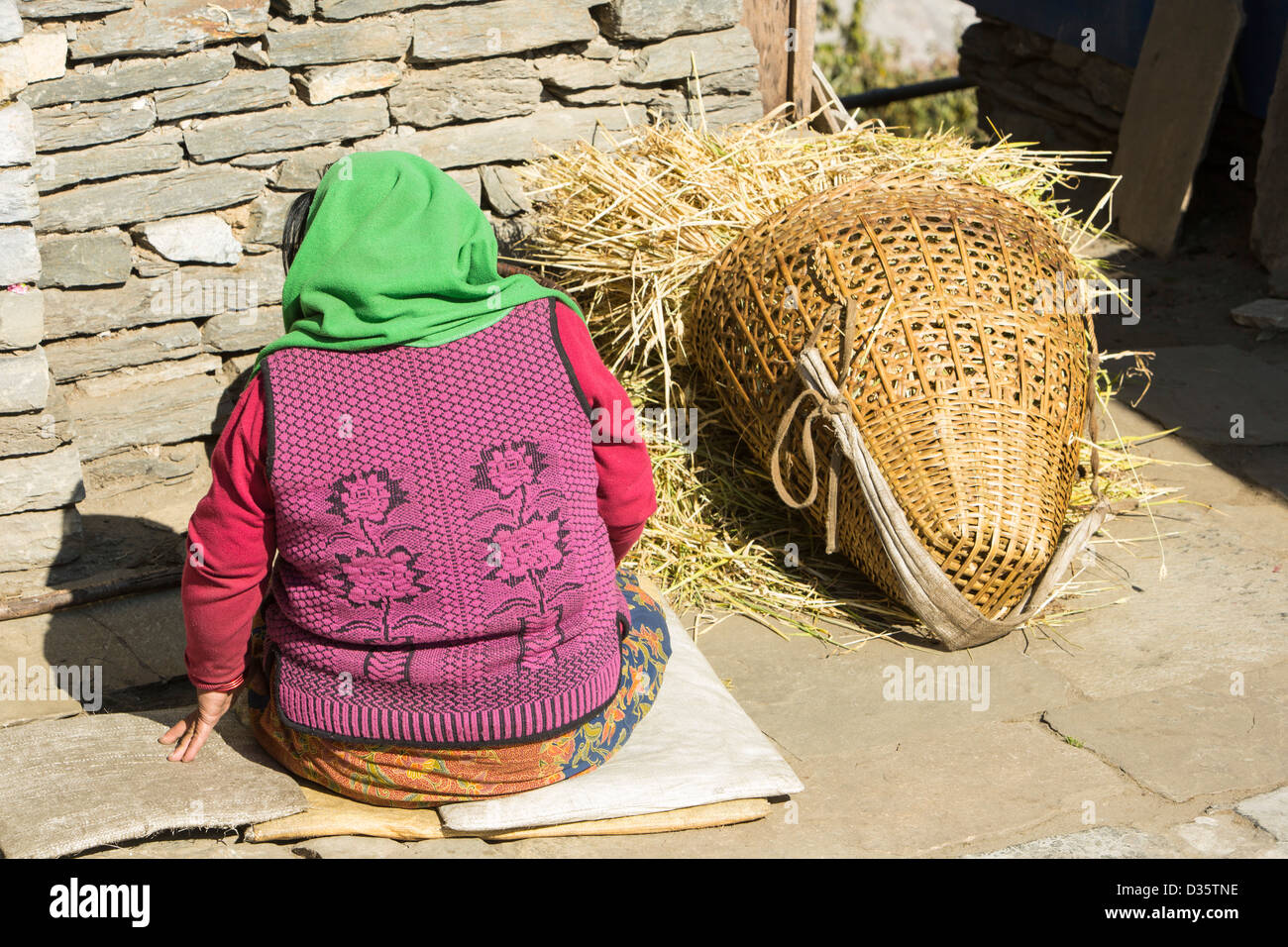 An old woman rests from carrying a load of hay in the Annapurna ...
