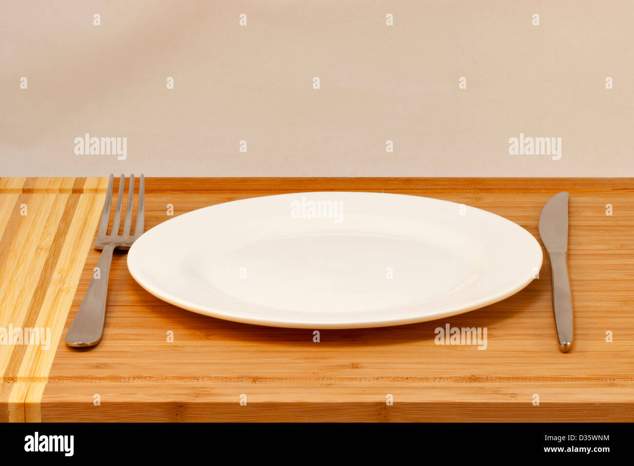 cutlery empty plate, table knife and fork on a wooden desk Stock Photo ...