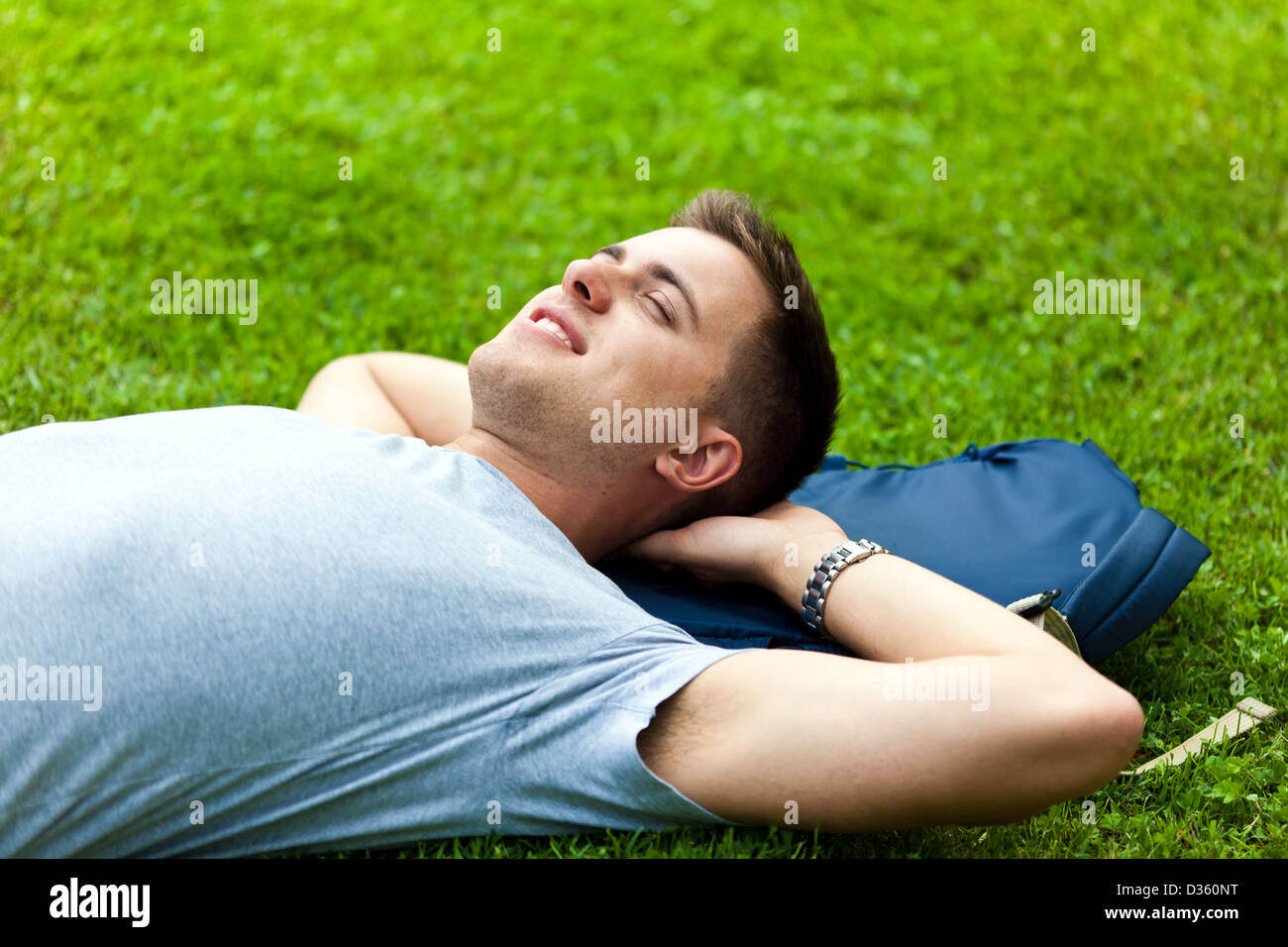 Student relaxing on the grass Stock Photo - Alamy