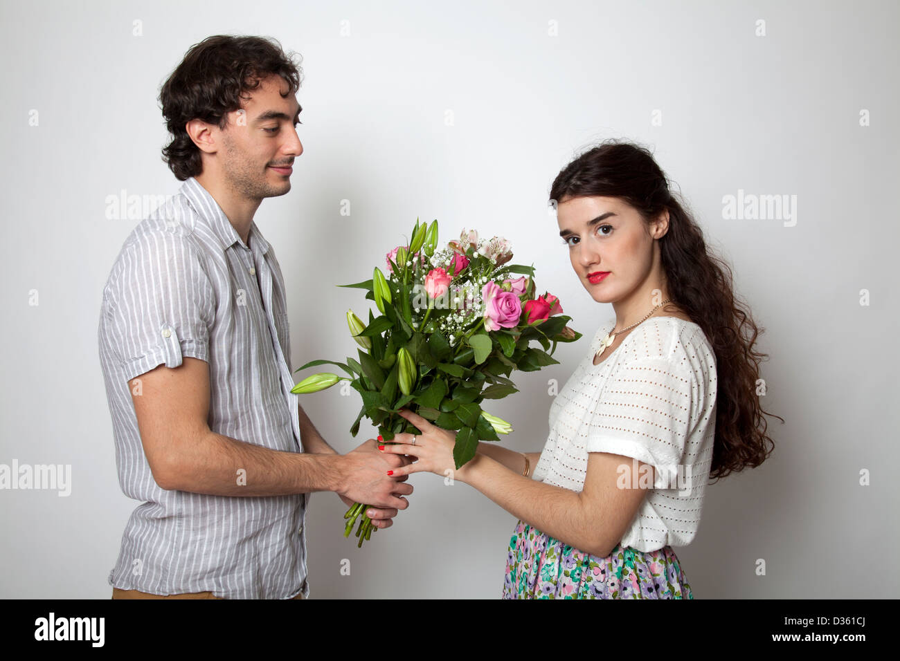 Man handing bouquet of flowers to woman Stock Photo - Alamy