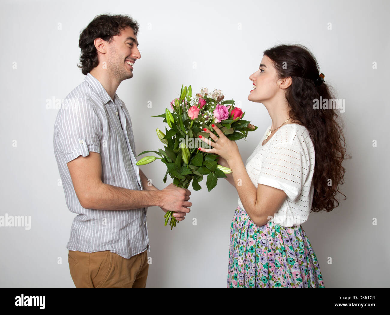 Man handing bouquet of flowers to woman Stock Photo - Alamy